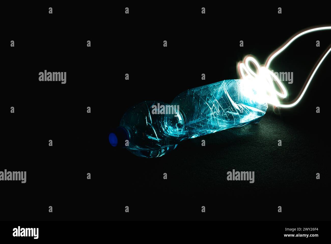 A crushed plastic bottle partially filled with water, lying ...