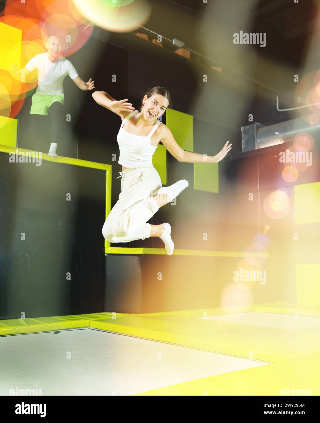 Cheerful young girl jumping in indoor trampoline arena Stock Photo - Alamy