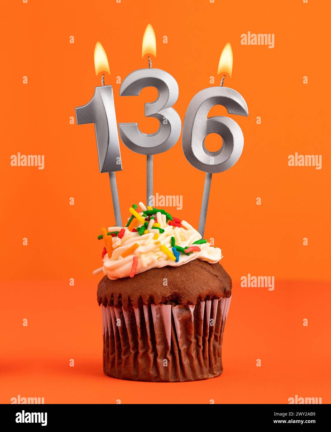 Birthday cupcake with number 136 candle - Orange color background Stock ...