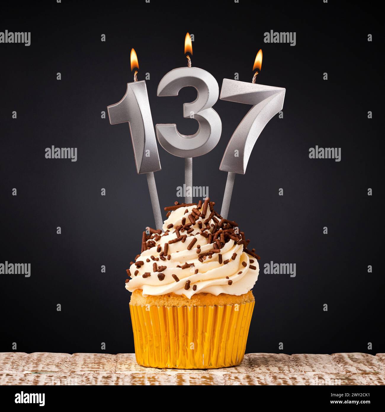 Birthday candle number 137 - Anniversary cupcake on black background ...