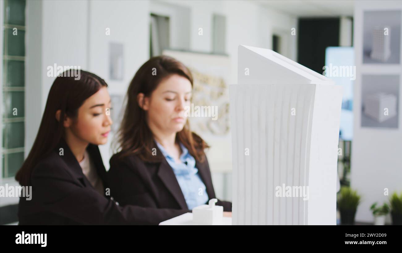Office engineers studying 3d printed model in coworking space ...