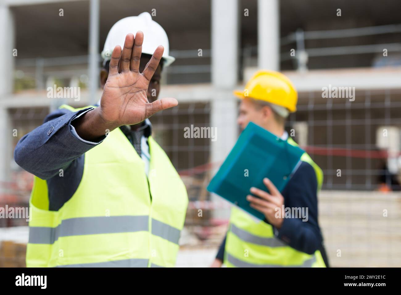 African-american engineer shows a stop sign with his hand about the ...