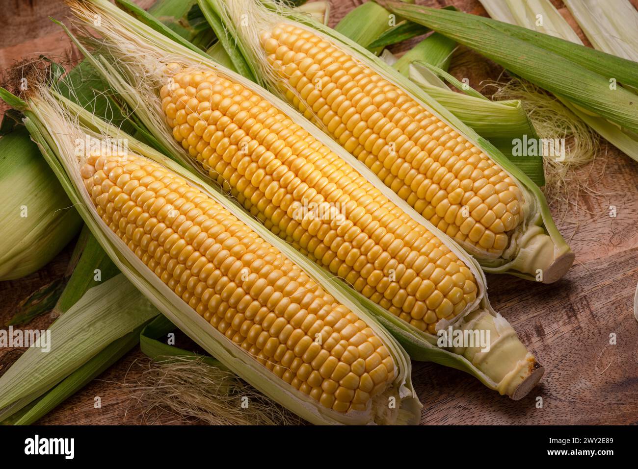 Ripe corn heads with corn whiskers and leaves. Nice vegetable cooking ...