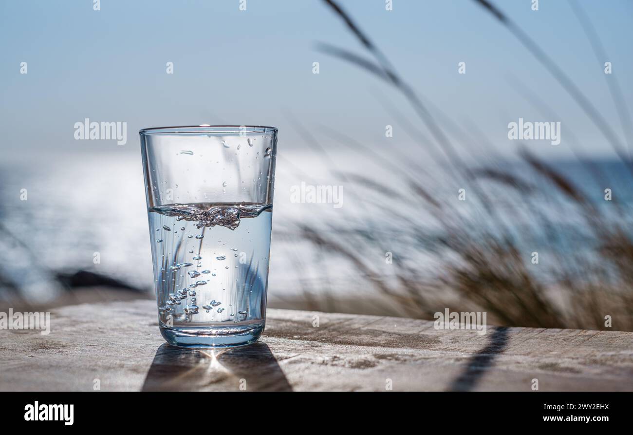 Pouring water into a glass from plastic bottle. Nature background Stock ...