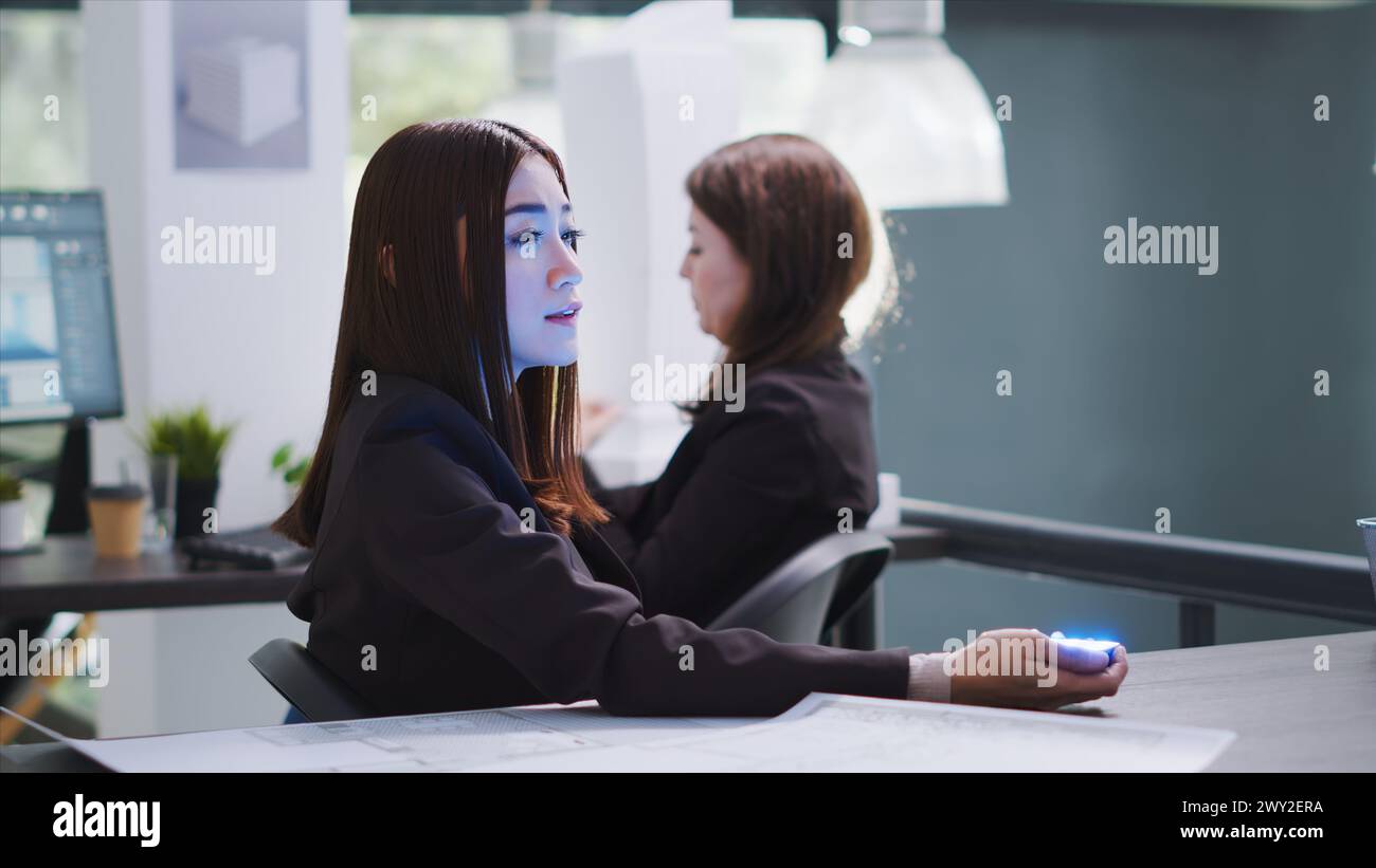 Developer talking to consultant on holographic projection in coworking ...