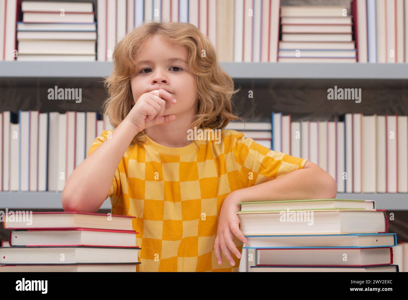 Elementary schoolboy. School boy doing homework on desk in school ...