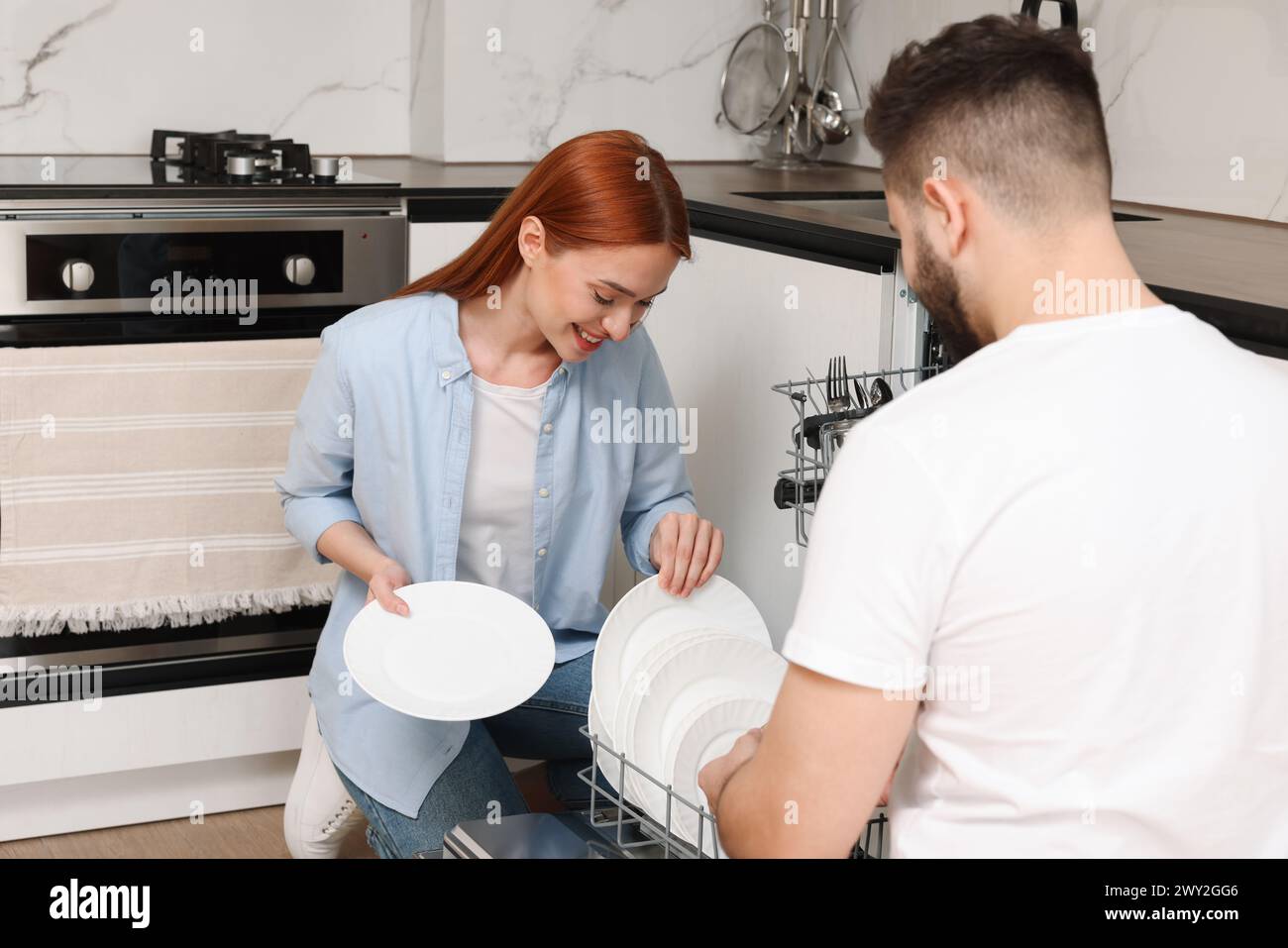 Woman loading dishwasher and man hi-res stock photography and images ...
