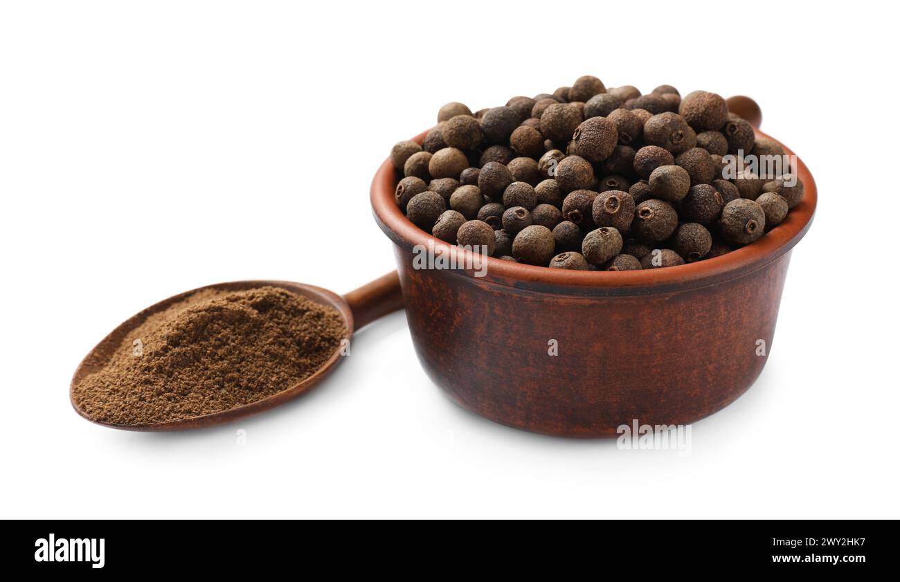 Aromatic ground allspice pepper, grains and spoon isolated on white ...