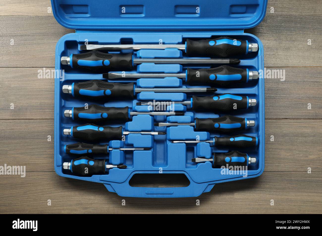 Set of screwdrivers in open toolbox on wooden table, top view Stock ...