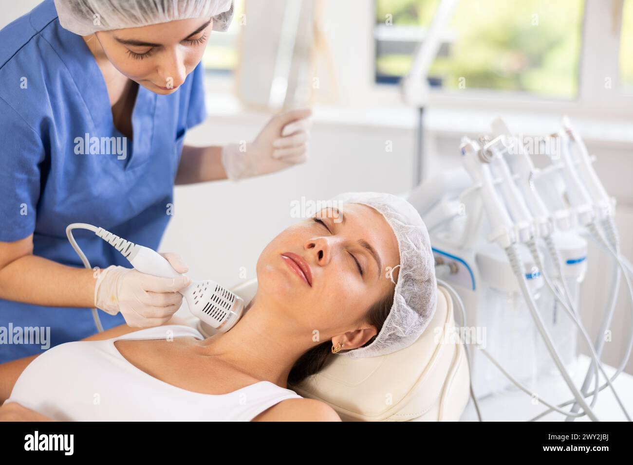 Female patient experiencing cryotherapy procedure on neck using ice ...