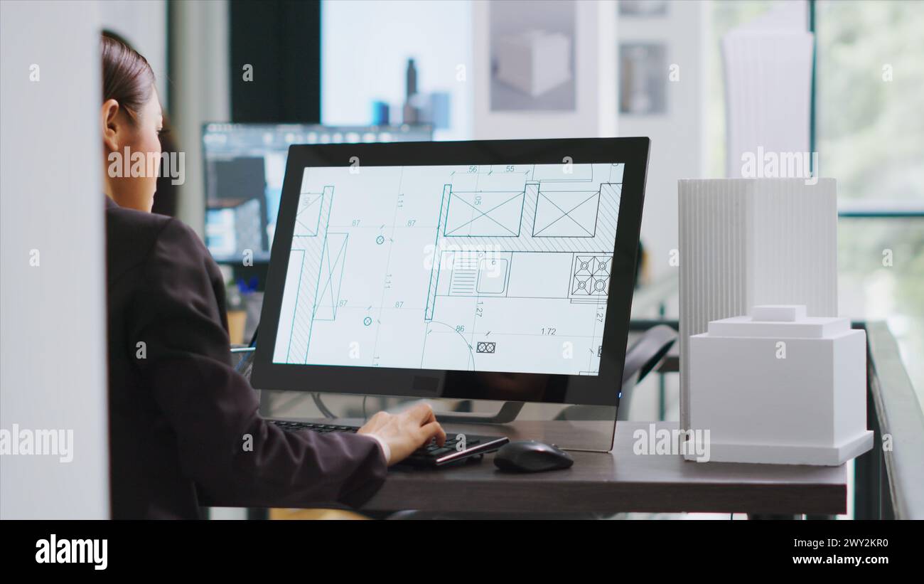 Technician operating on cad software to create blueprint for new architectural scaling project ...