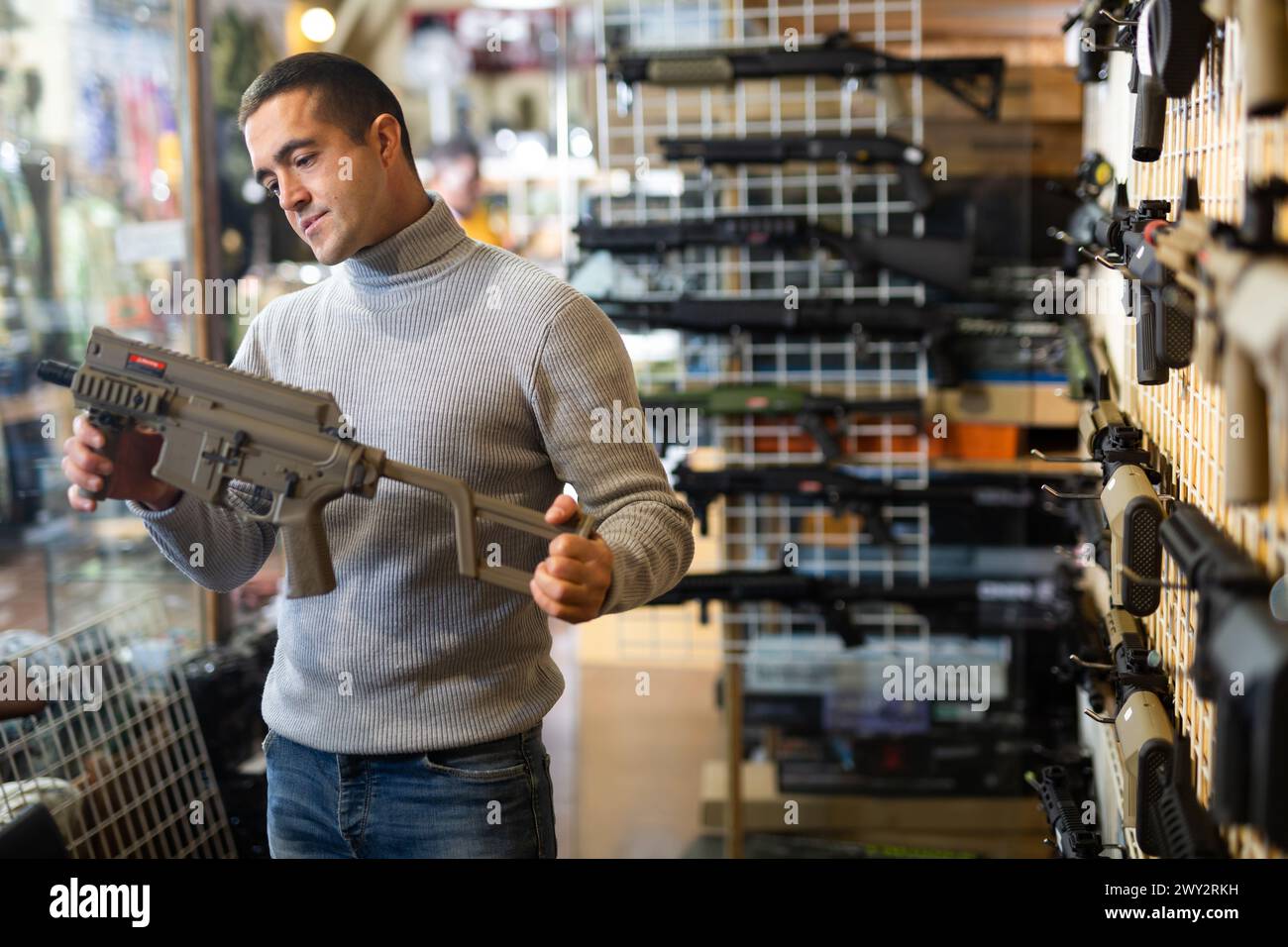 Man chooses semi-automatic pneumatic assault rifle at gun store Stock ...