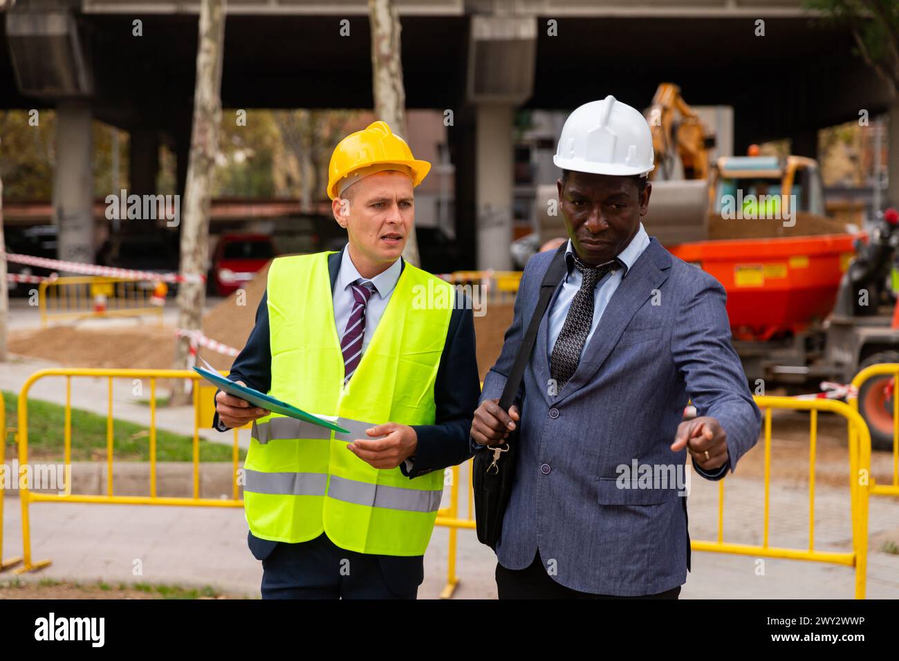 Engineer and architect are discussing options for laying a pipe on ...