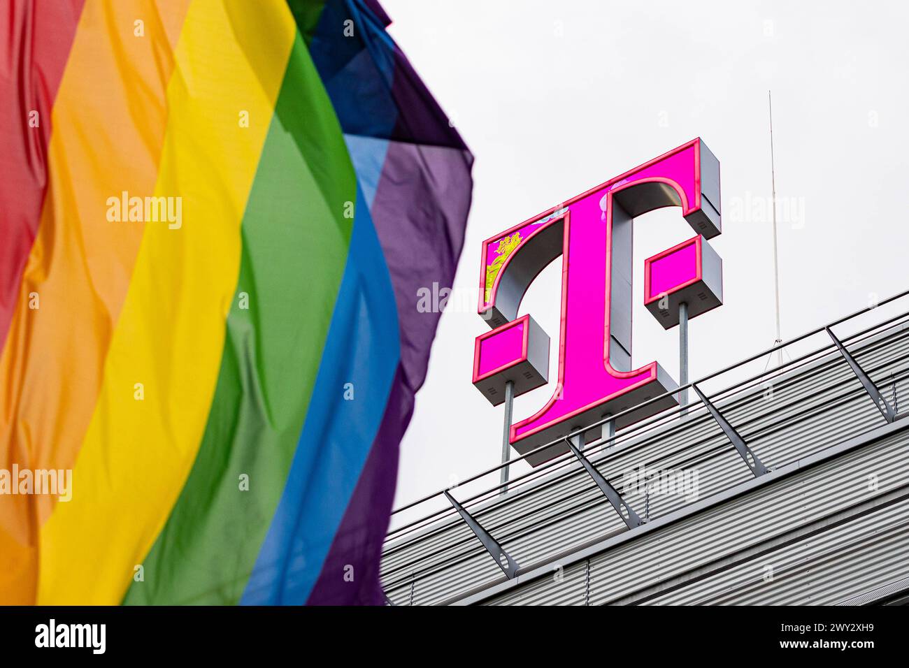 Die LGBTQ Fahne vor dem Telekom Logo - Das Logo vom Weltkonzern ...