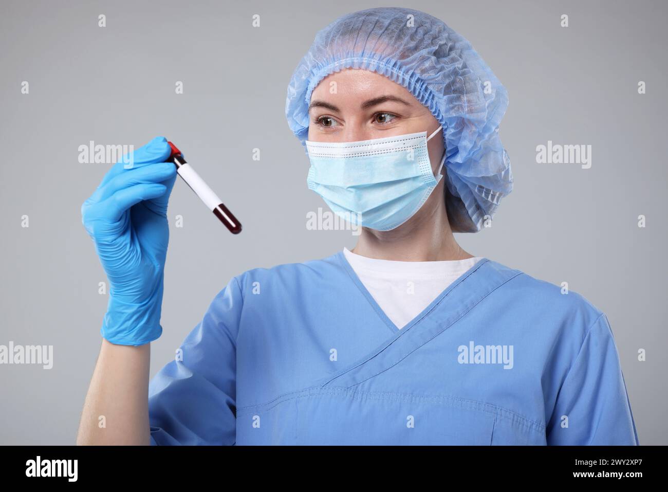 Laboratory testing. Doctor with blood sample in tube on light grey ...