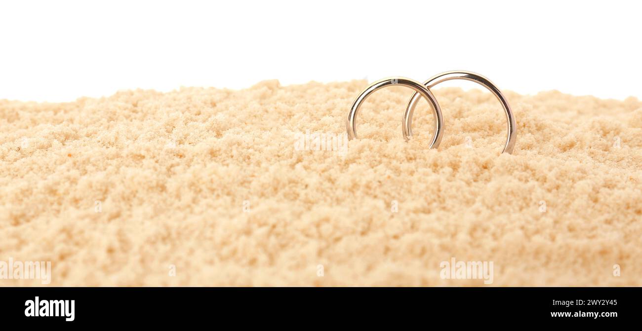 Honeymoon concept. Two golden rings and sand isolated on white Stock ...