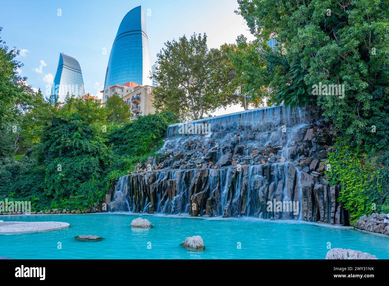 Flame towers viewed behind waterfall at selale park in Baku, Azerbaijan ...