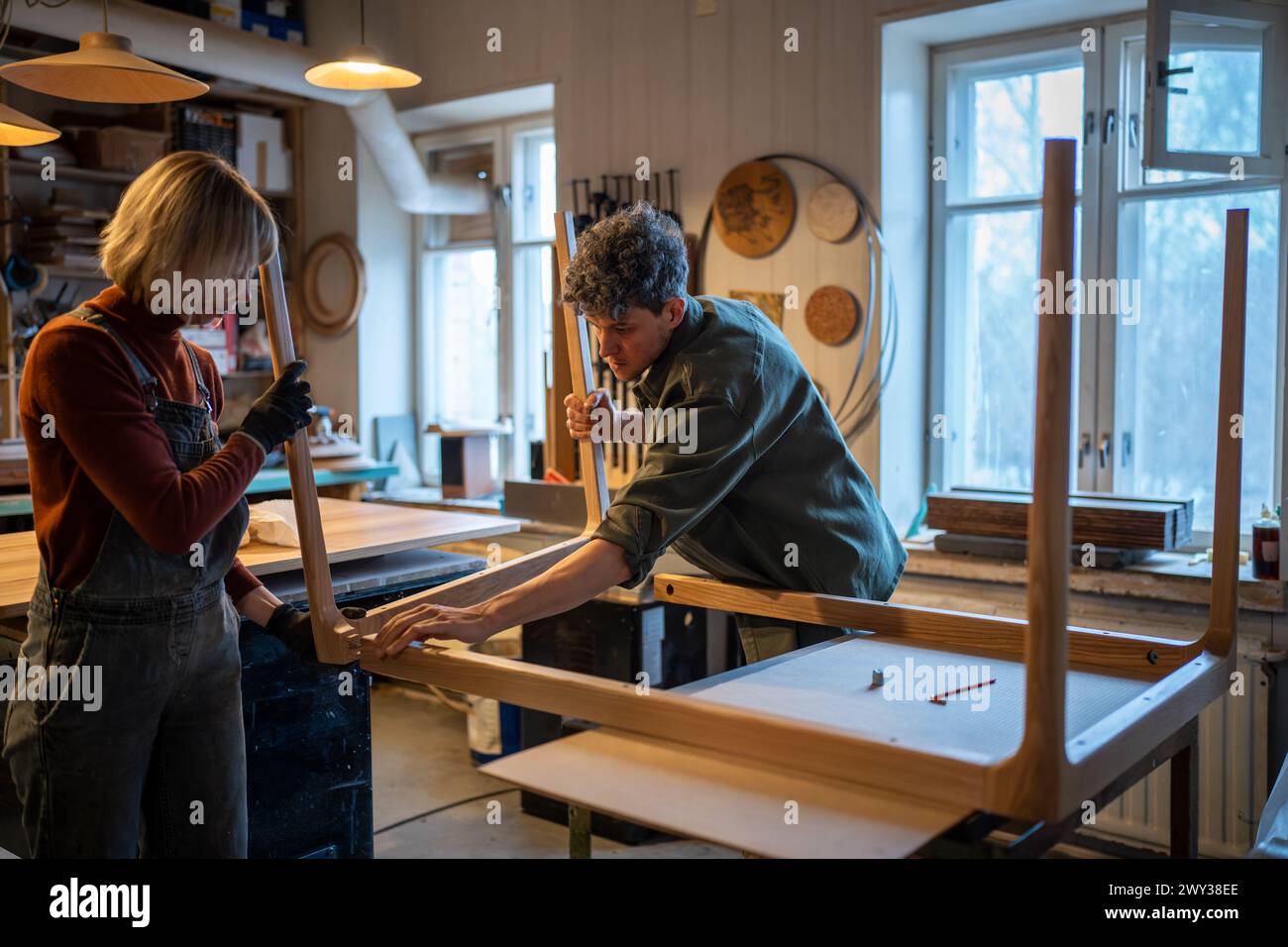 Carpentry workshop, craftsmen working together. Woman and man ...