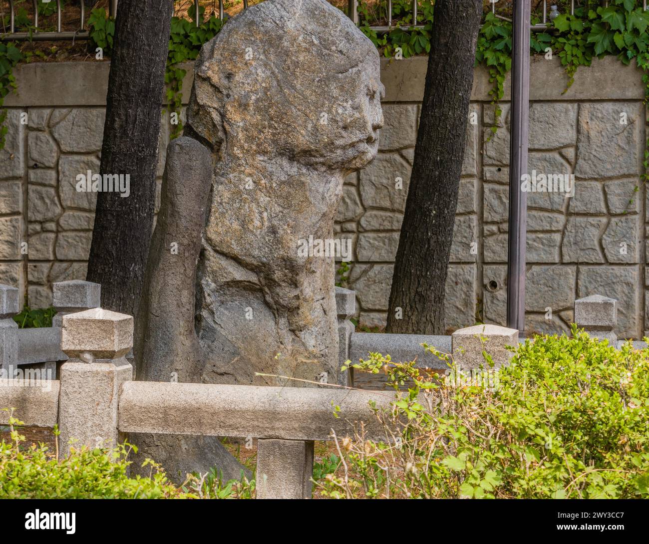 Side view of large stone guardian posts in city park protected with ...