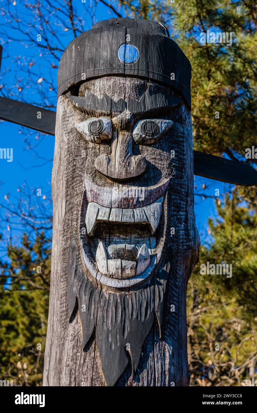 Closeup of carved face of wooden totem pole used long ago to protect ...