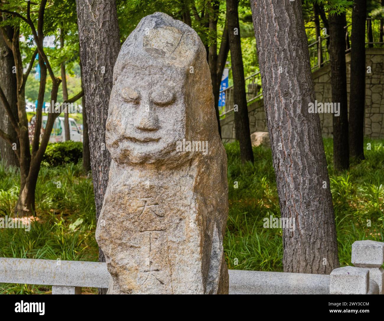 Stone guardian with Chinese symbols protected with concrete fence ...