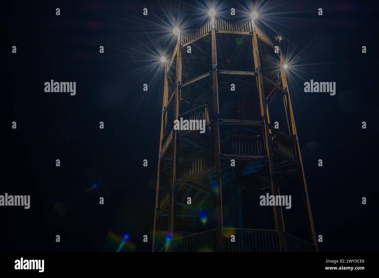 Low angle night view of wooden observation tower illuminated by flood ...