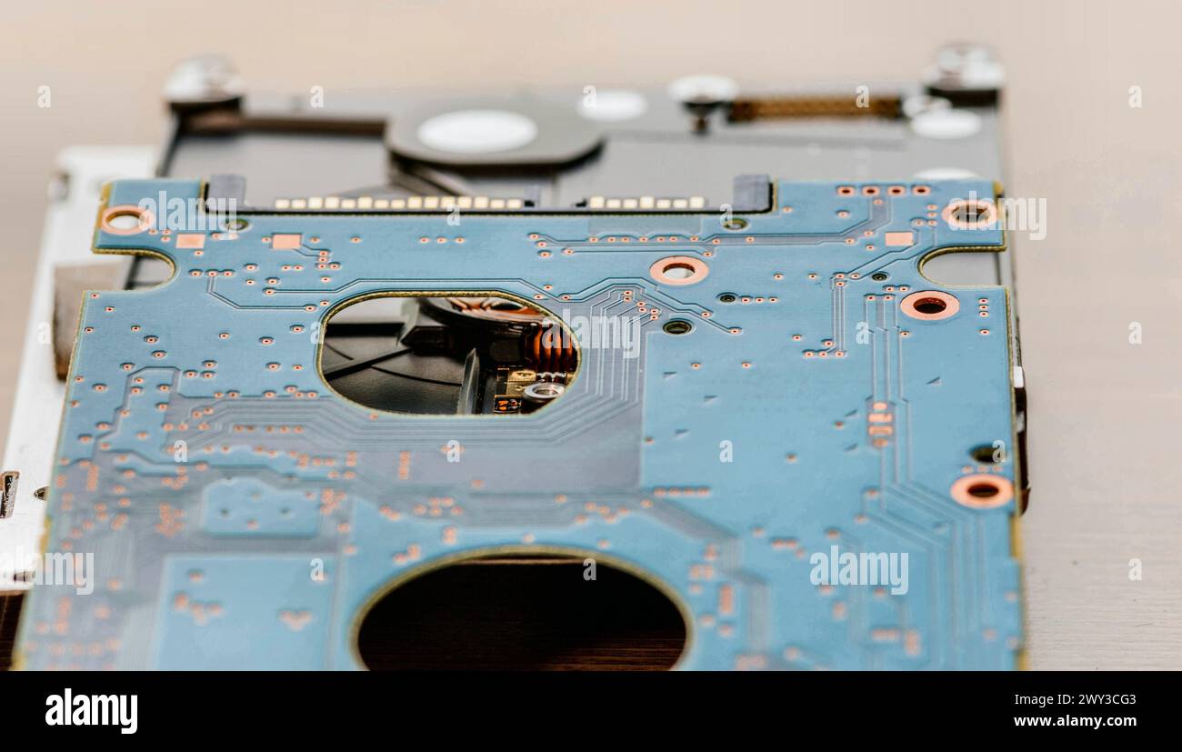 Laptop computer hard drive with the circuit board removed and laying on ...
