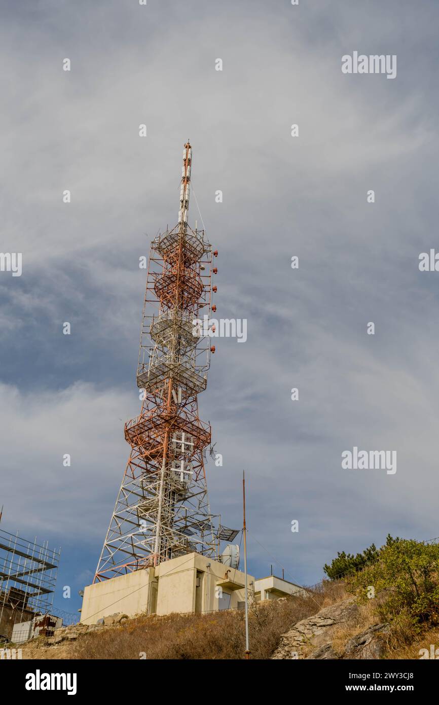 Image of a communication tower with complex antennas against a backdrop of clouds, in South ...