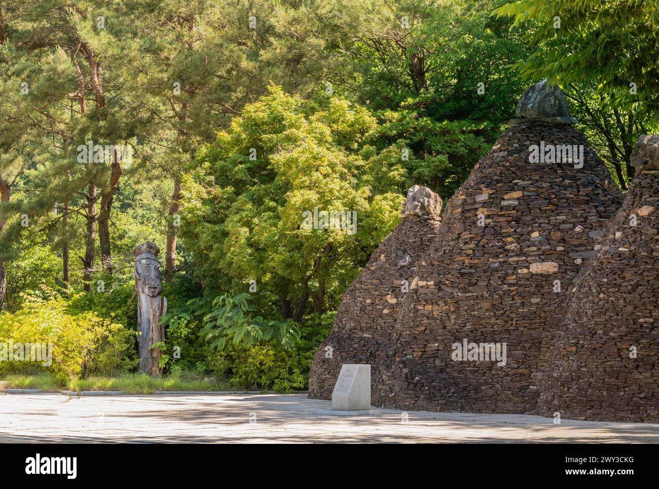 Three large time capsules made of stone and rocks stacked in shape of ...