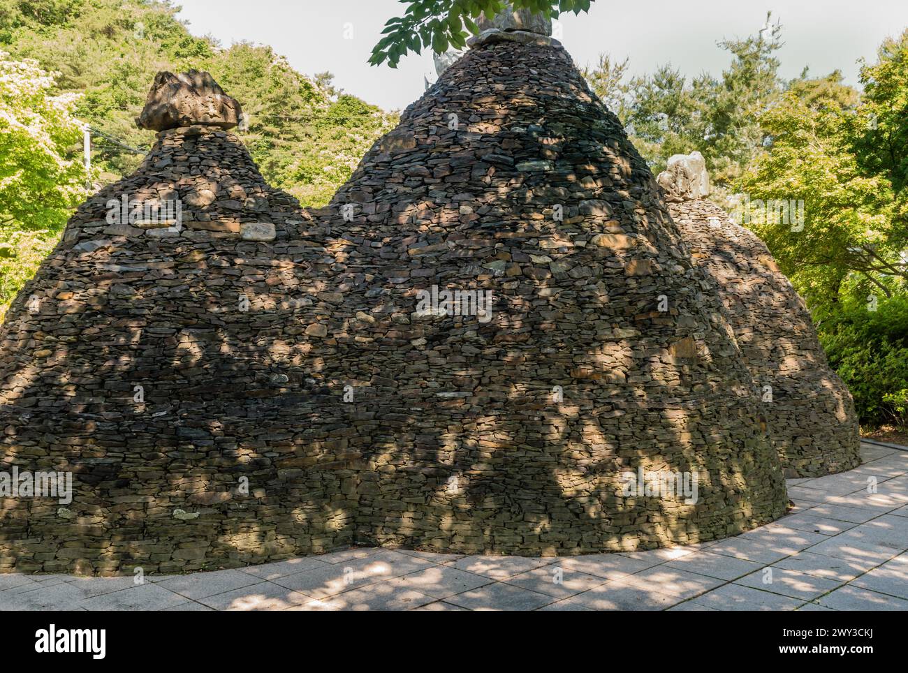 Three large time capsules made of stone and rocks stacked in shape of ...