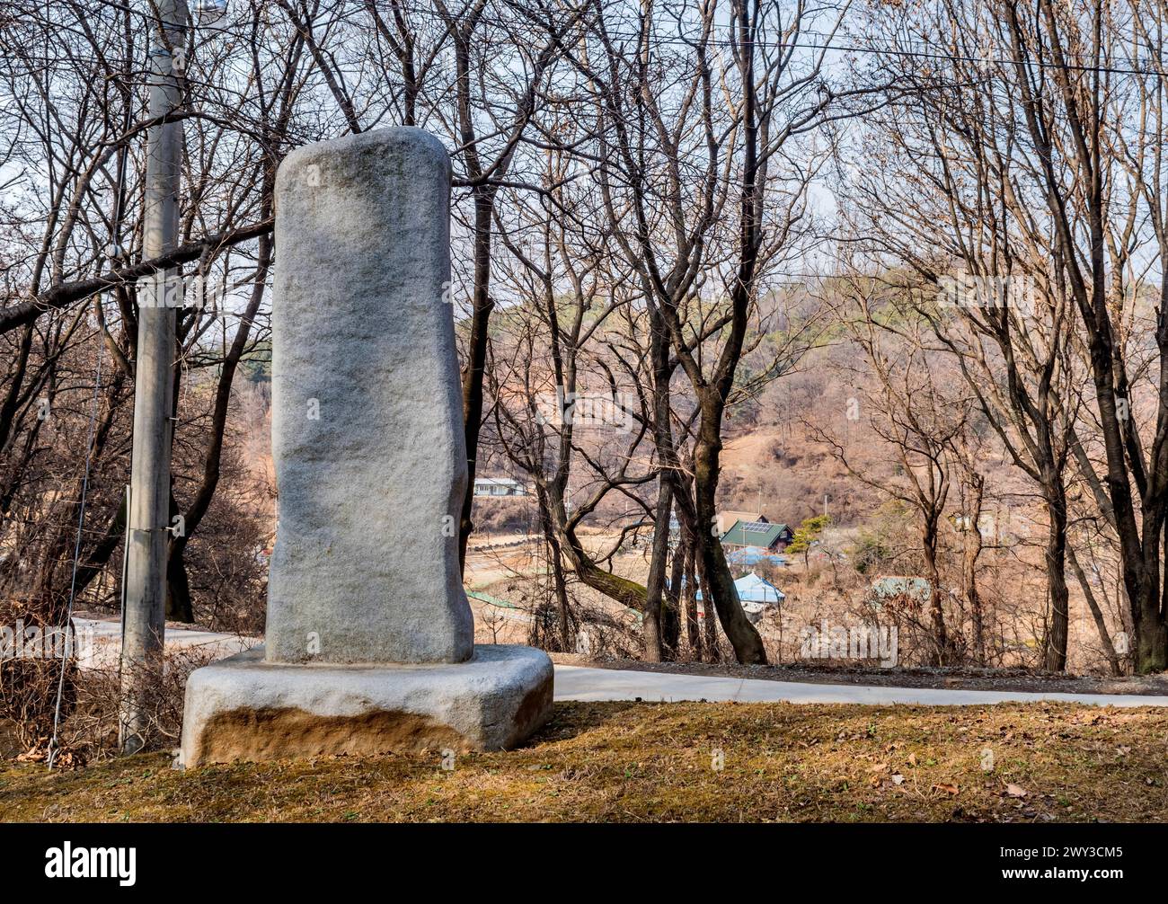Large concrete stele standing next to one lane road in countryside in ...
