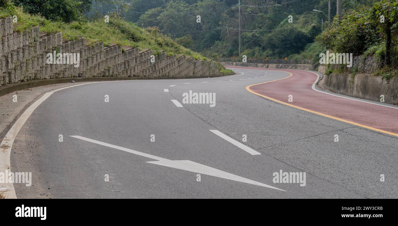 Closeup of arrow on curvy mountain road indicating end of slow vehicle ...