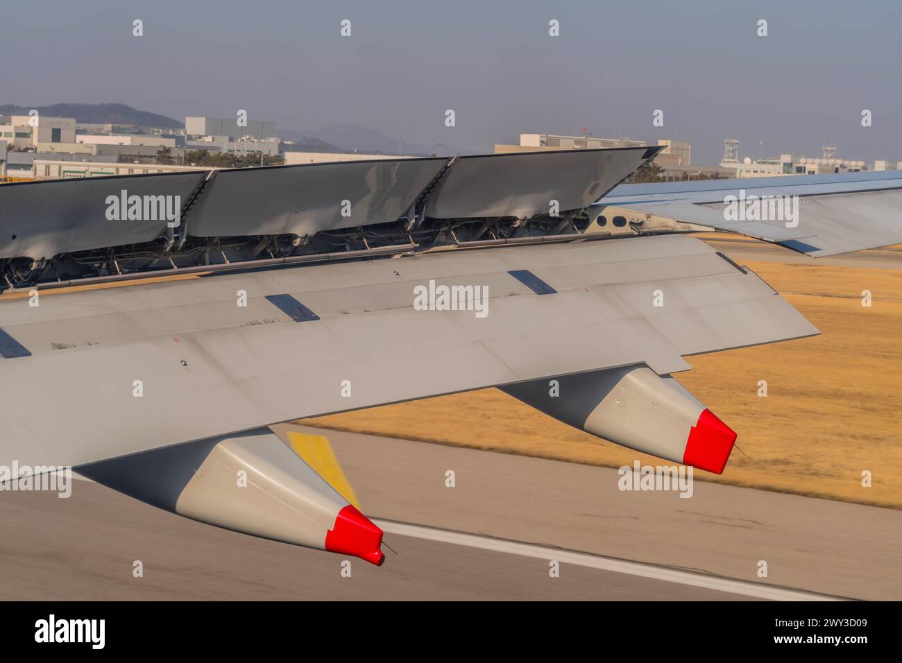 Aircraft wing with breaking flaps extended during landing with airport ...