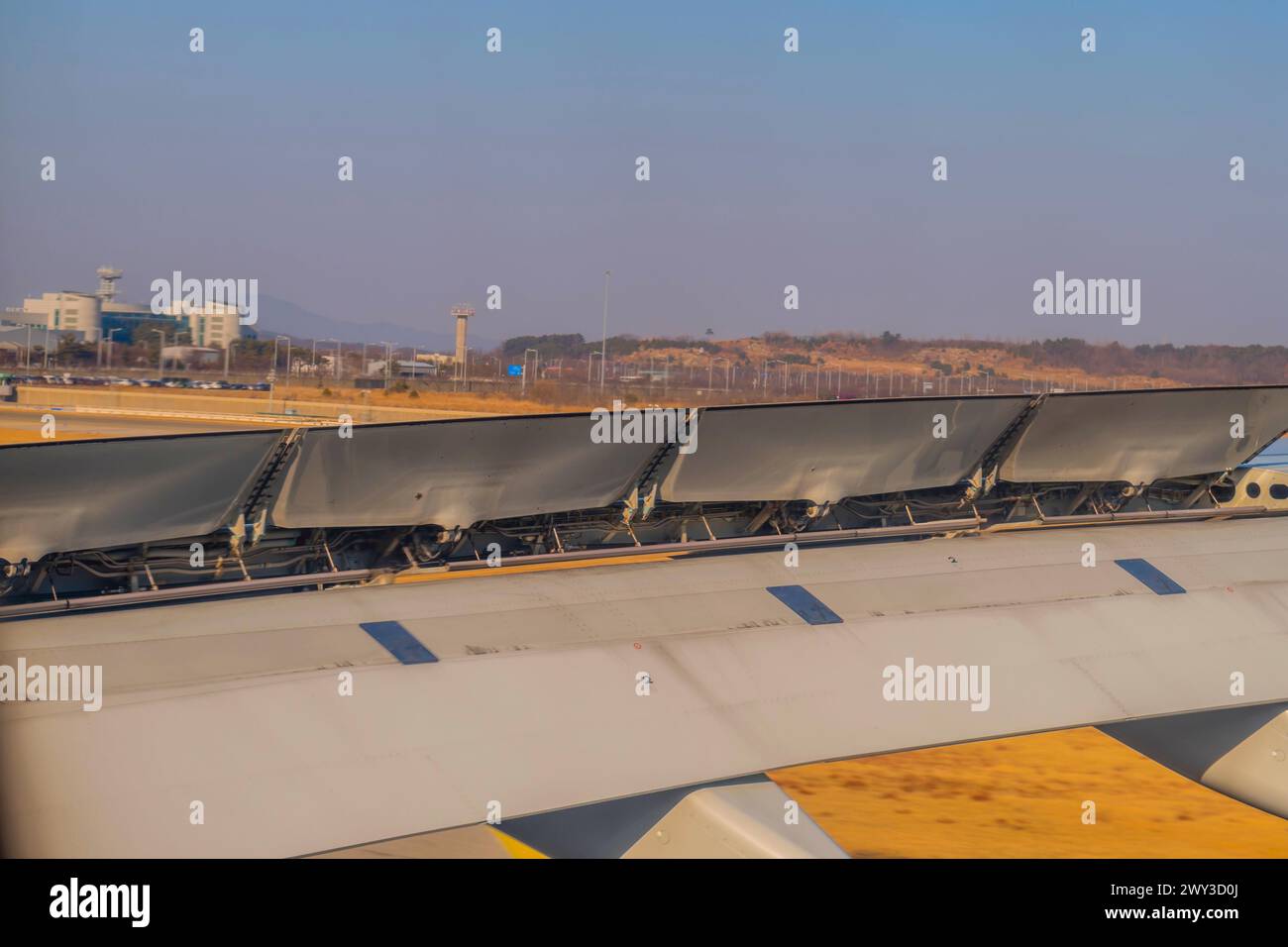Aircraft wing with breaking flaps extended during landing with airport ...