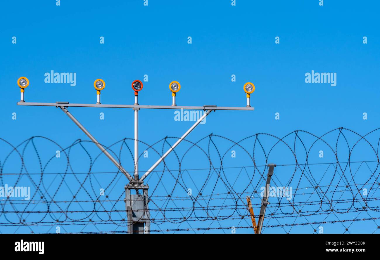 Landing strip lights on triangular metal support behind barbed wire ...