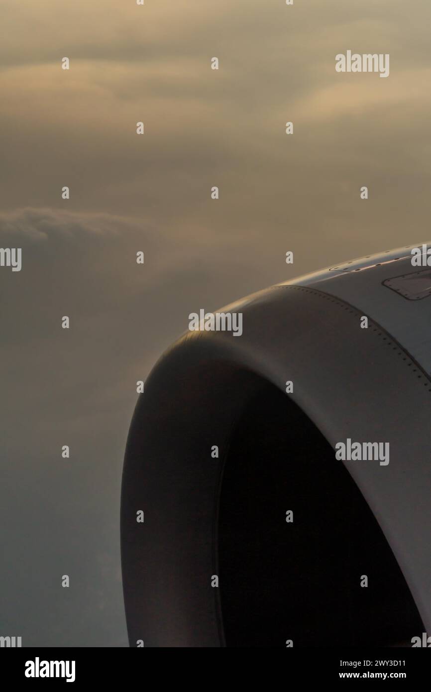 Closeup of cowling of jet engine with cloud cover in background. Taken ...