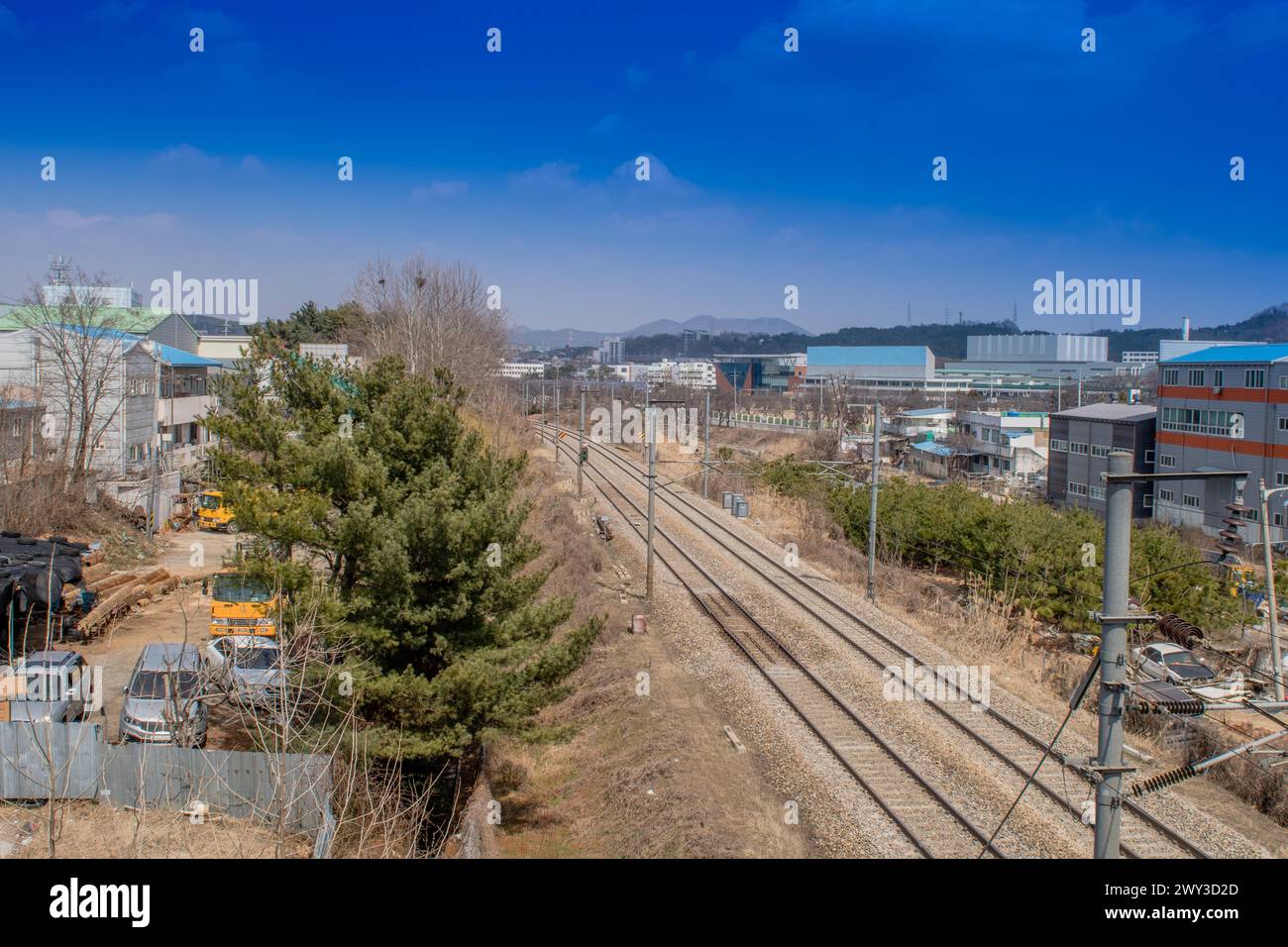 Train tracks running through industrial area on outskirts of small town ...