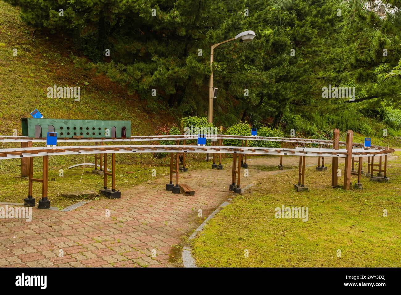 Miniature outdoor train station with benches and lampposts surrounded ...