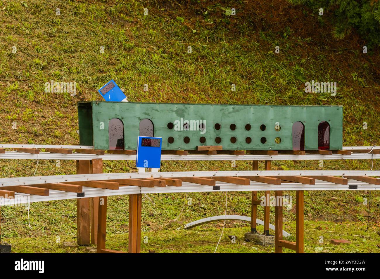 Close-up of a miniature railway track segment with circular holes and ...