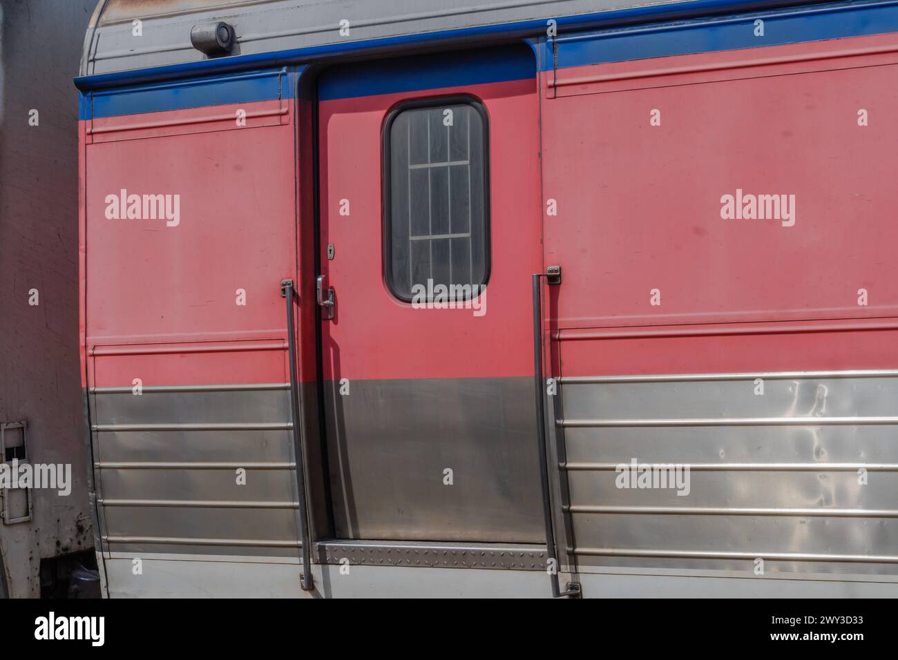 Red and silver train carriage door with metal handles, in South Korea ...