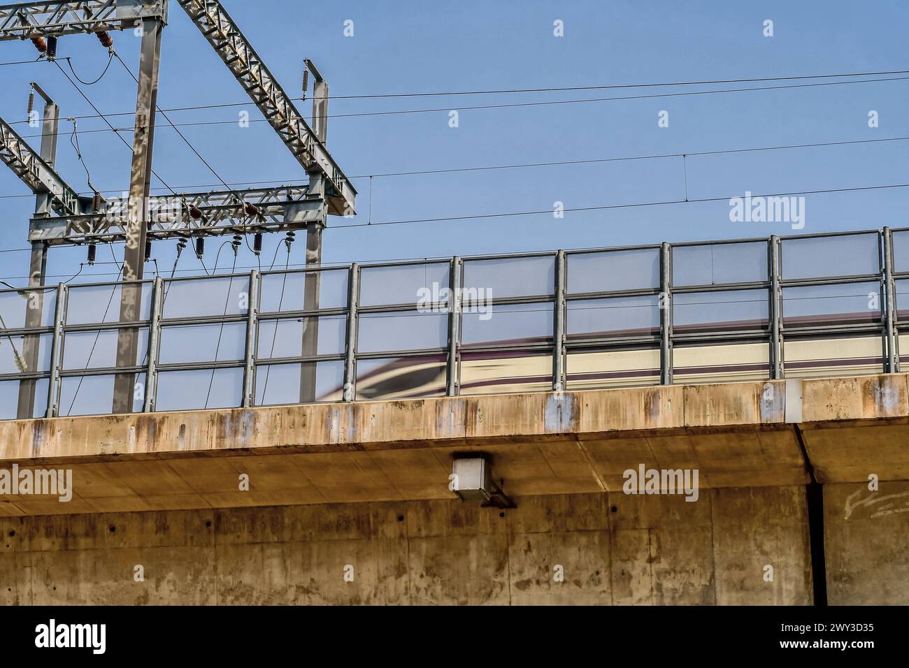 Low angle view of speeding train crossing concrete rail bridge under ...