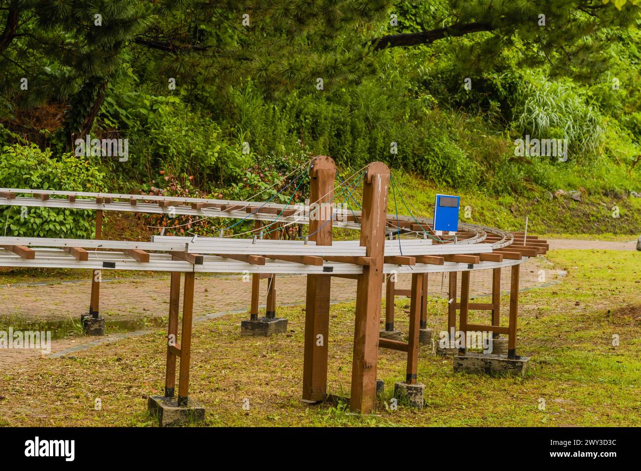 Miniature train tracks supported by wooden structures in a park setting ...
