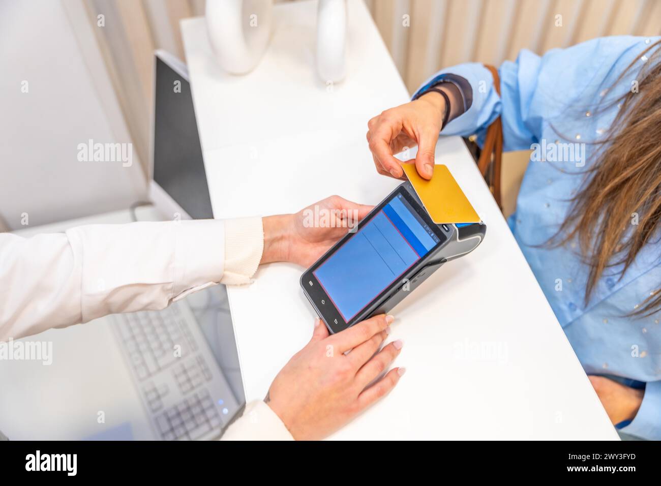 Top view of an unrecognizable woman paying with credit card in a beautician clinic Stock Photo ...