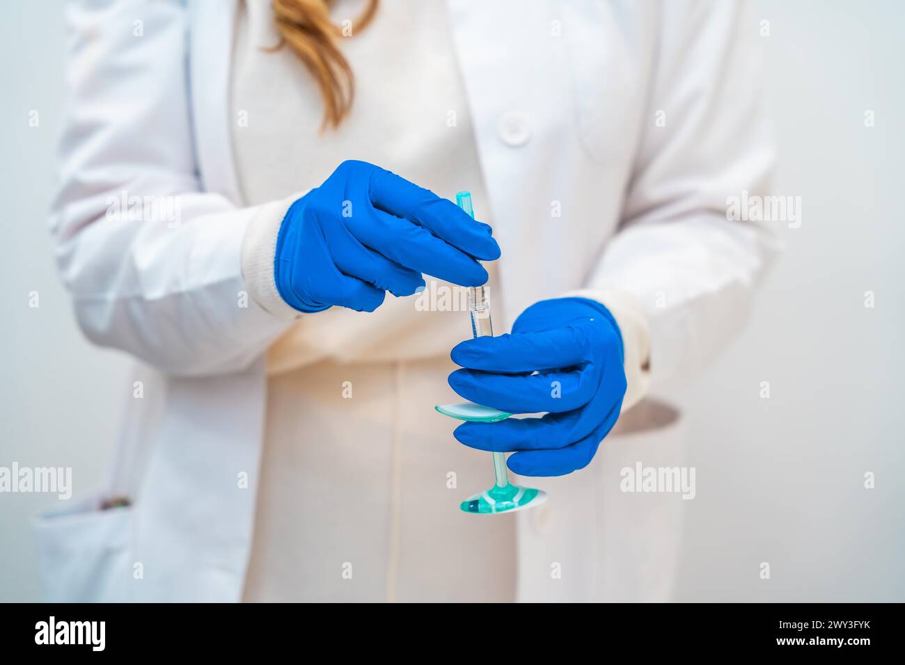 Part of and close-up of a female doctor holing a botox injection in an ...