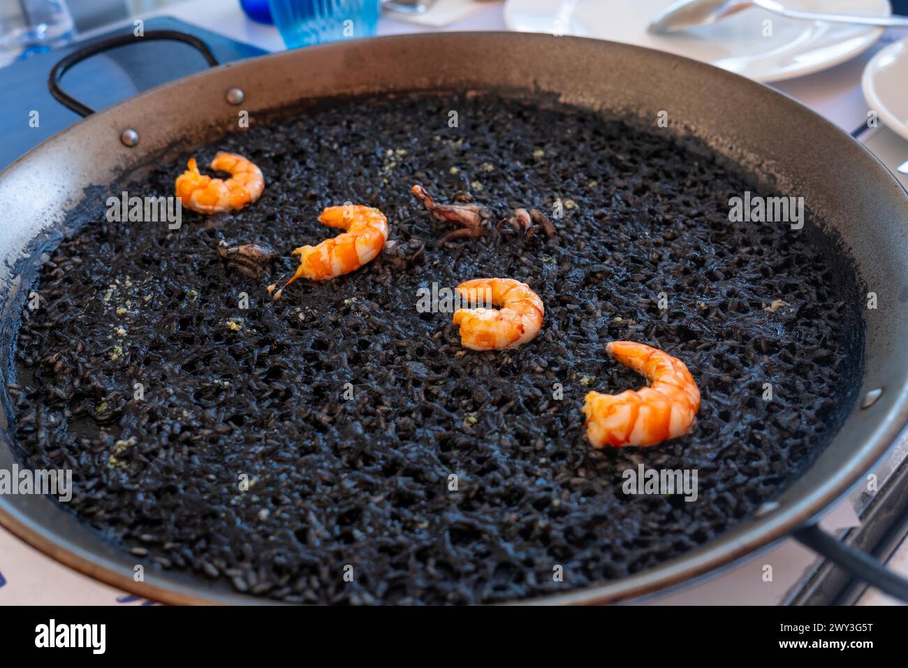 Black rice with prawns and squid, a dry rice, cooked in paella or in a ...