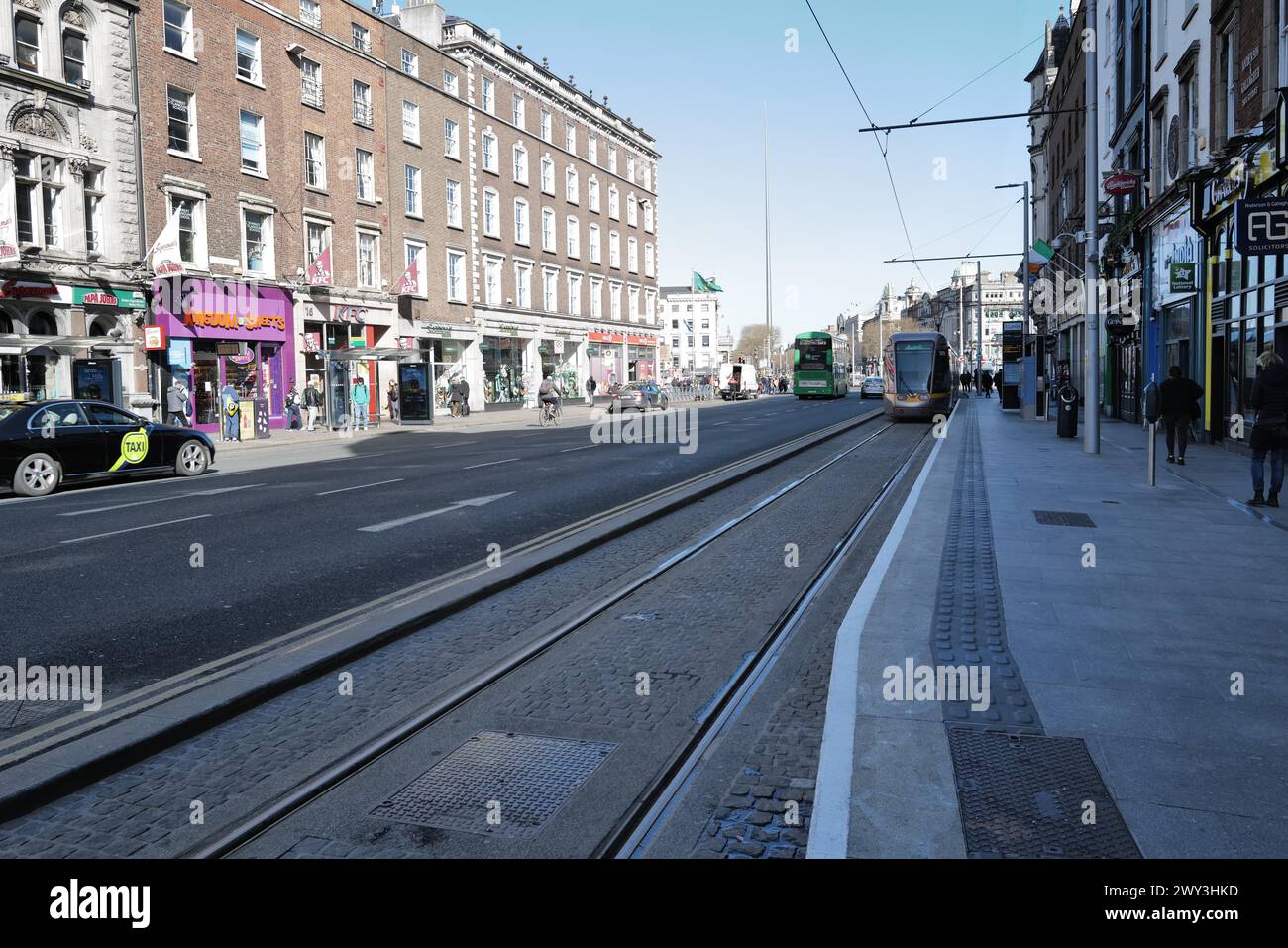 A taxi, tram and bus on a bright day with the famous Spire in the ...