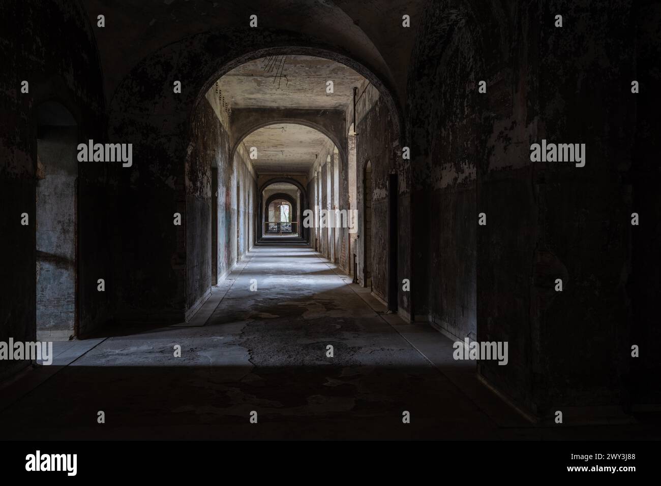 A dark, deserted corridor with vaulted ceilings leads into a mysterious depth ...