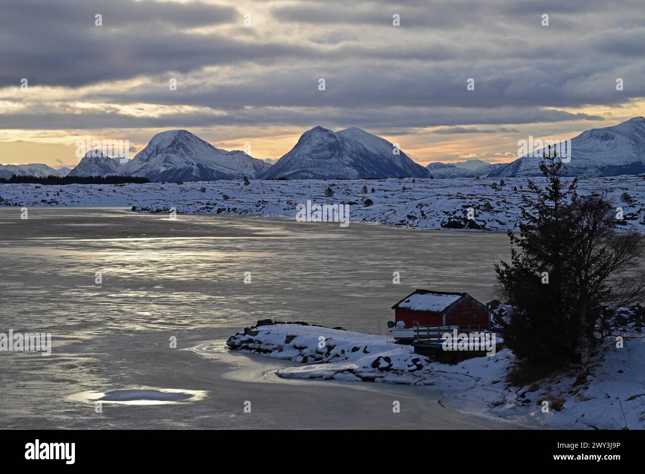 Icy lake in the middle of a mountainous landscape, Smola Island, Norway ...