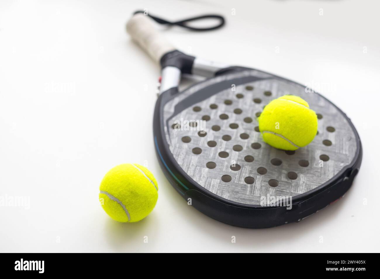 Set of paddle tennis rackets and balls the reflected on white table and ...