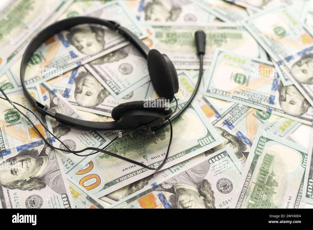one hundred dollar bills and headphones. Close-up Stock Photo - Alamy